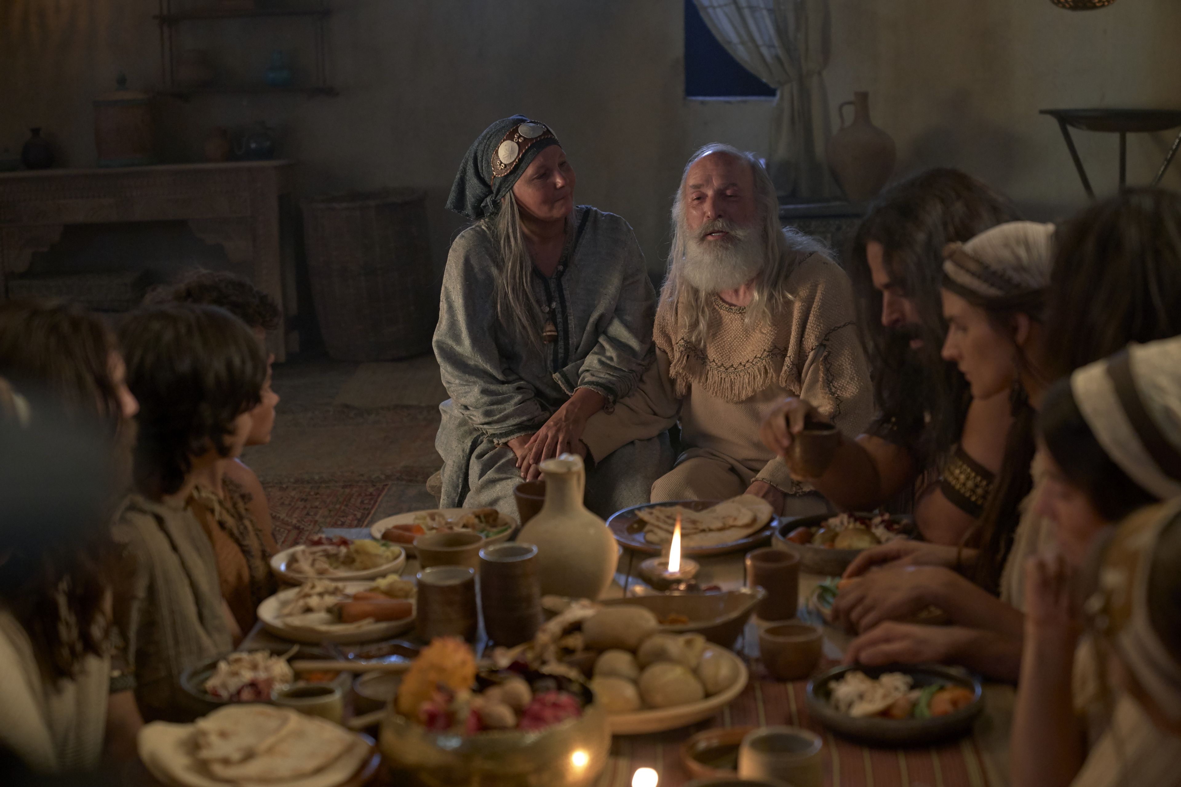 Lehi and Sariah teaching their family while dining